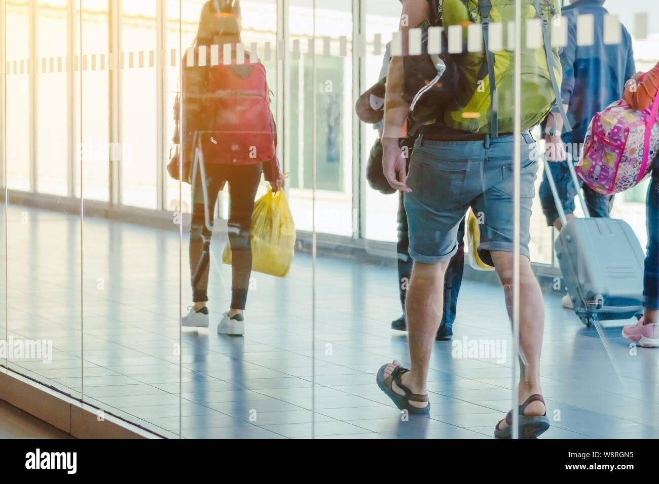 Back view of passengers and traveling luggage walking the airplane ...