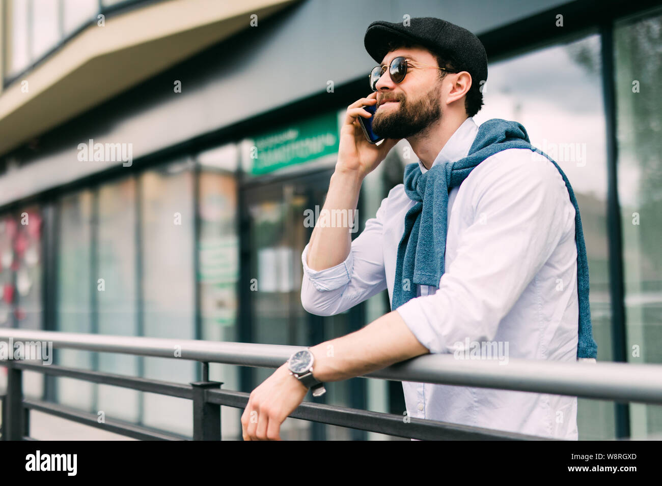 Image of happy young man walking on the street and looking aside while ...