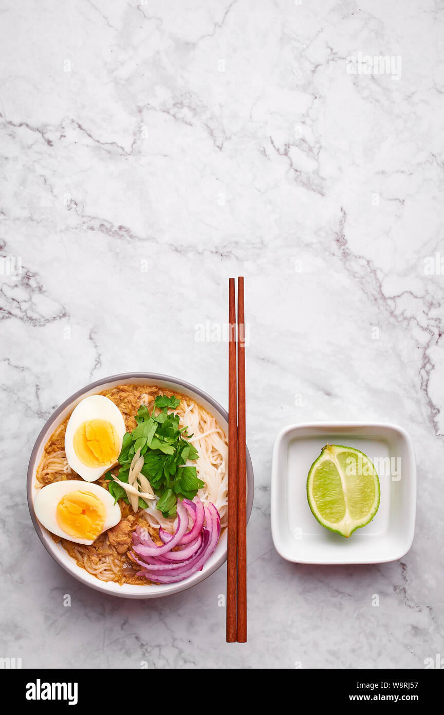 Mohinga at white marble background. Mohinga is a burmese cuisine fish ...