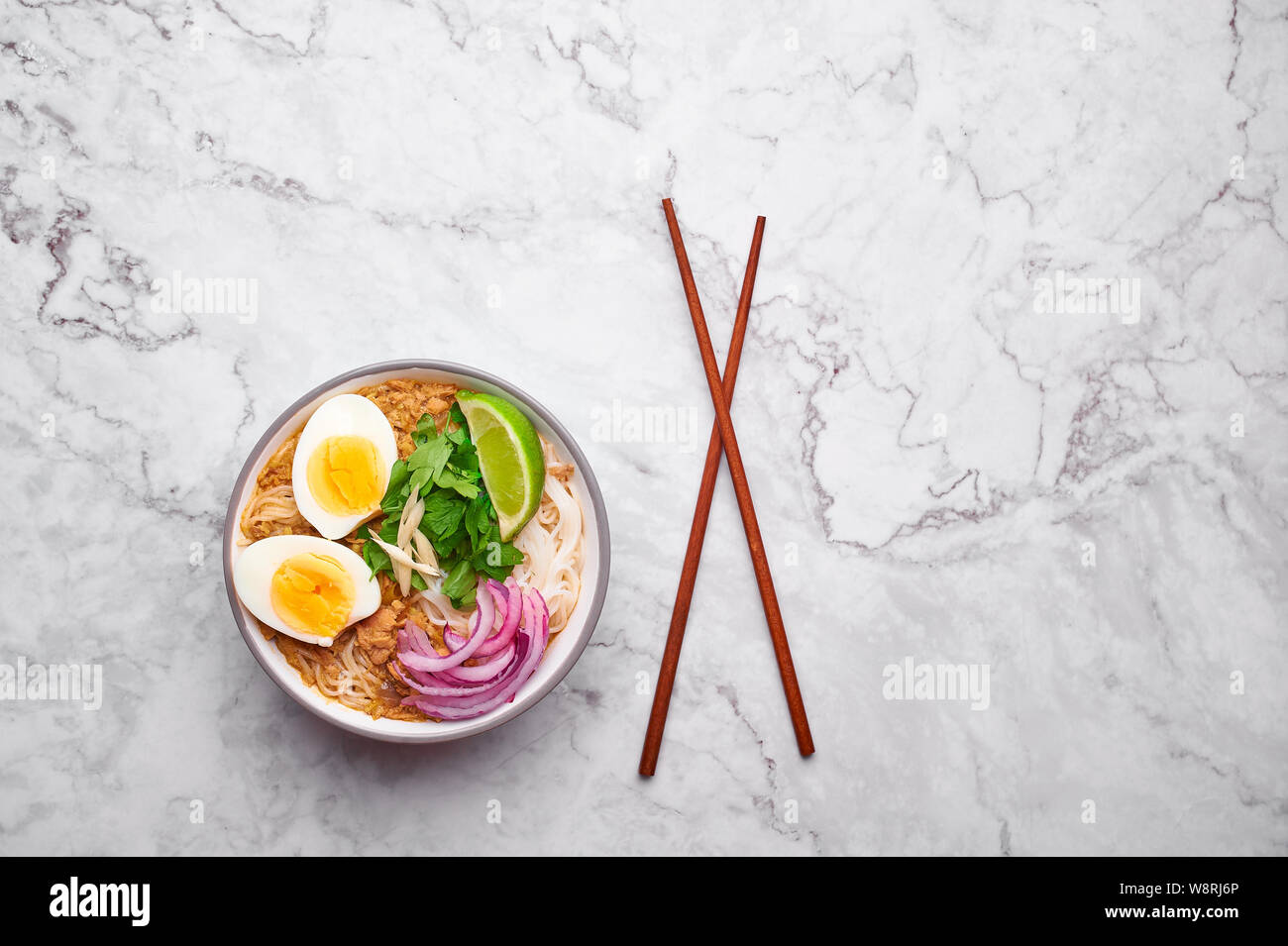 Mohinga at white marble background. Mohinga is a burmese cuisine fish ...