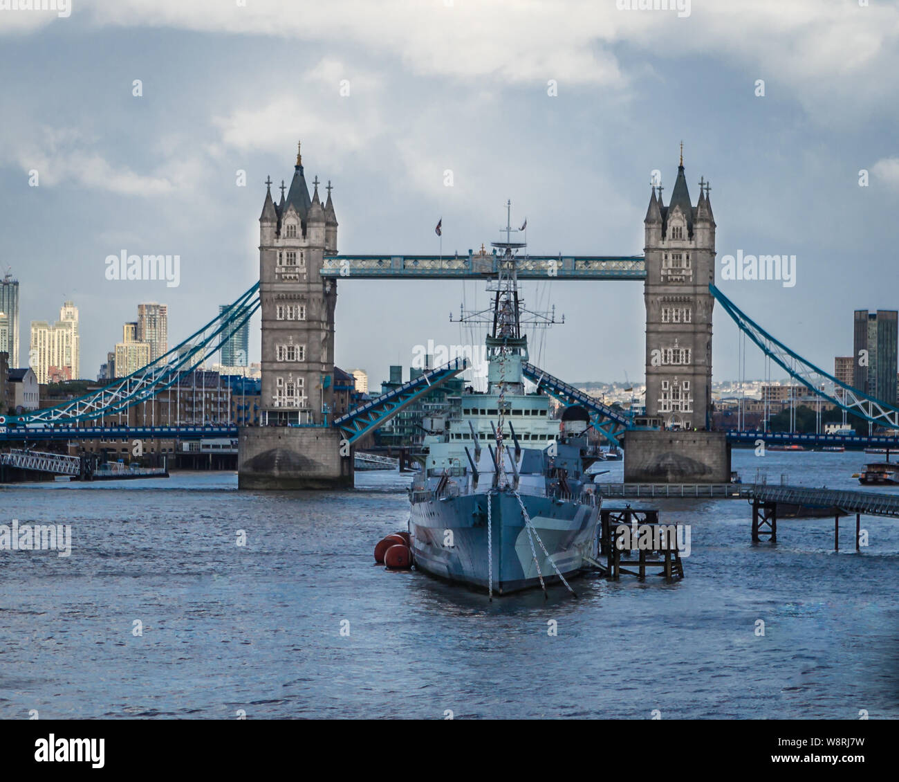 Tower Bridge is open behind the iconic HMS Belfast, on the River Thames Stock Photo - Alamy