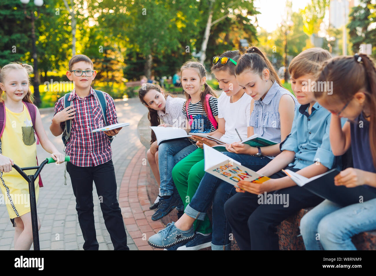 Happy Schoolmates Portrait. Schoolmates seating with books in a wooden ...