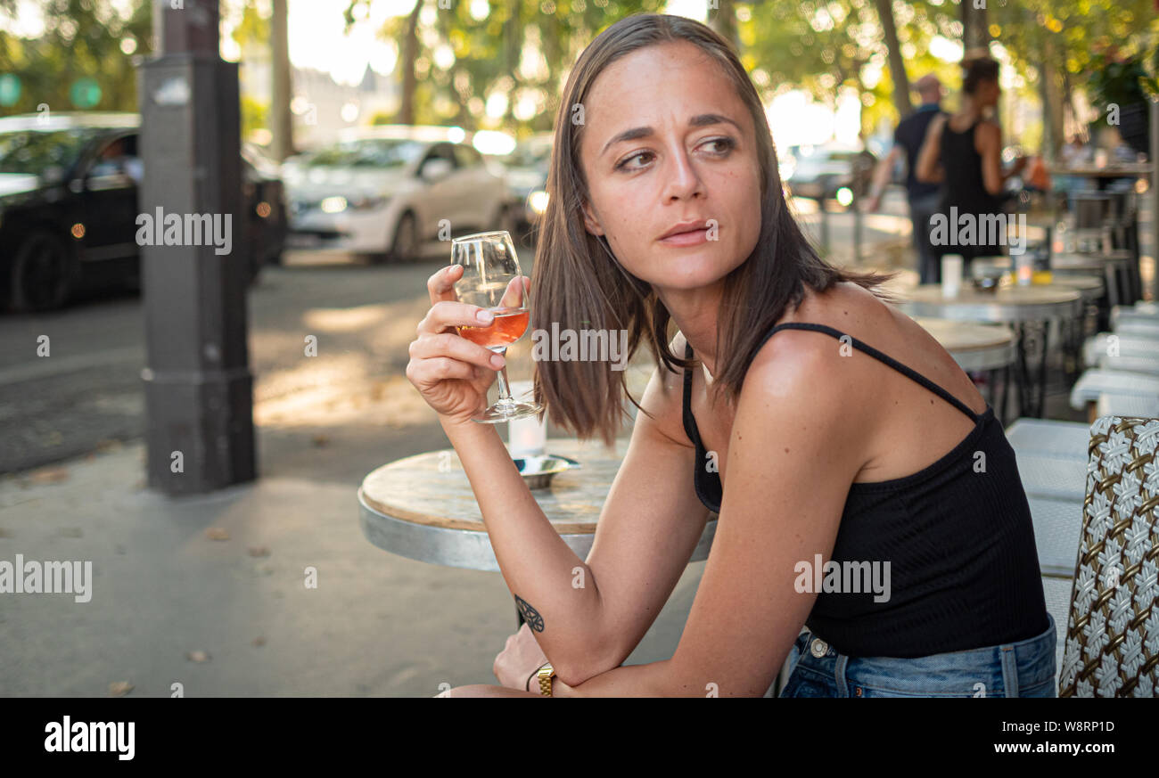 French woman drinks a glass of wine in a street cafe in Paris - Paris ...