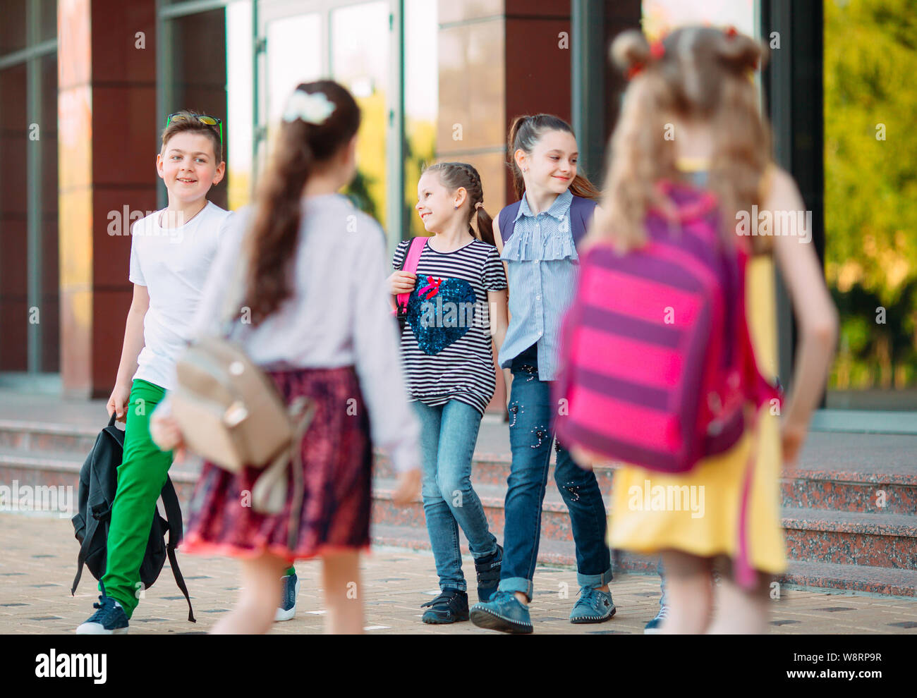 Schoolmates go to school. Students greet each other Stock Photo - Alamy