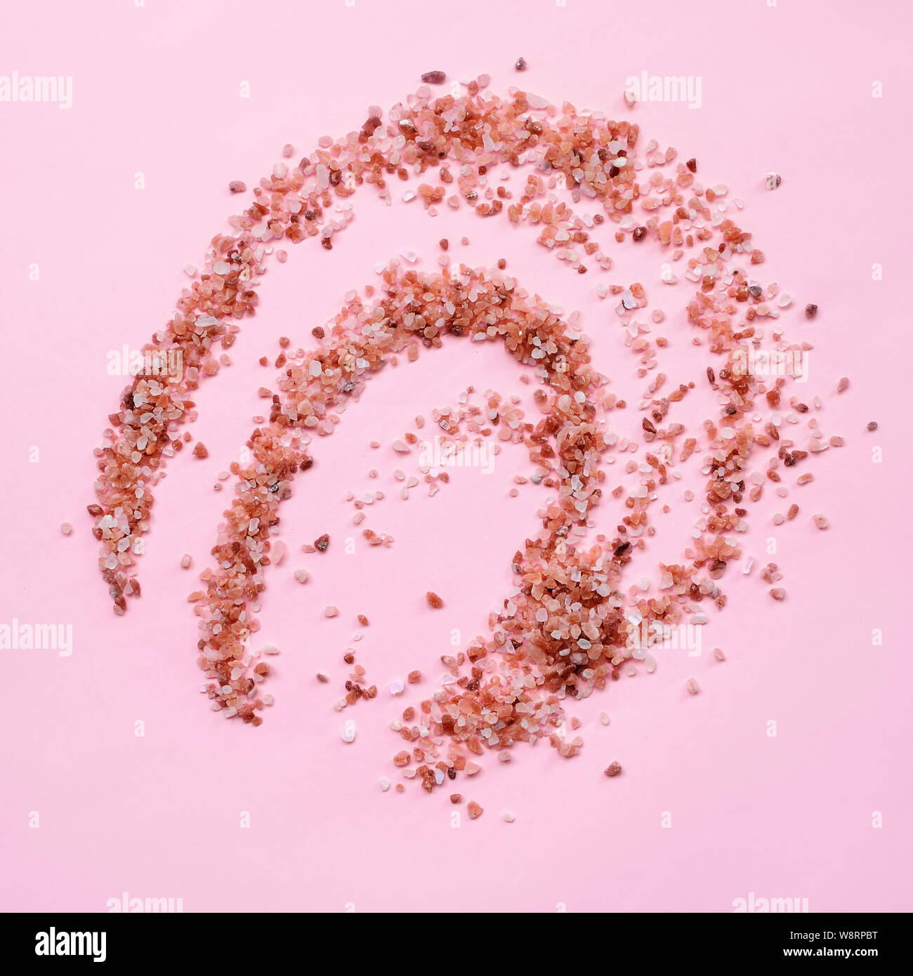 Large crystals of pink himalayan salt scattered on a pastel pink ...