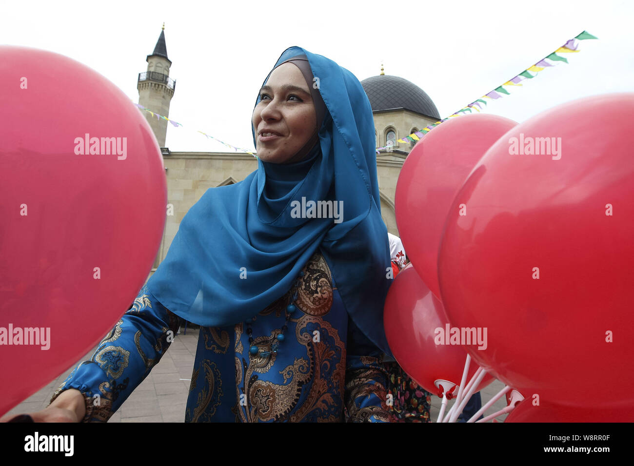 Kiev, Ukraine. 11th Aug, 2019. A muslim woman holds red balloons during ...