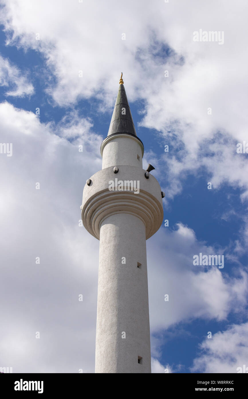Minaret of a Muslim mosque on the background of the cloudy sky. one ...