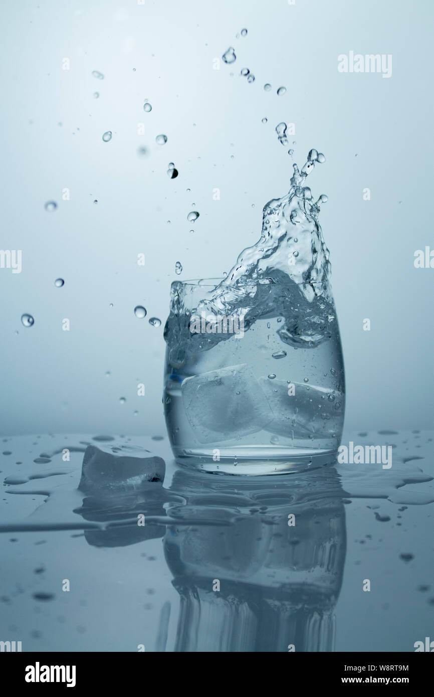 High splash with splashes of pure cold water. Ice falls into a clear ...