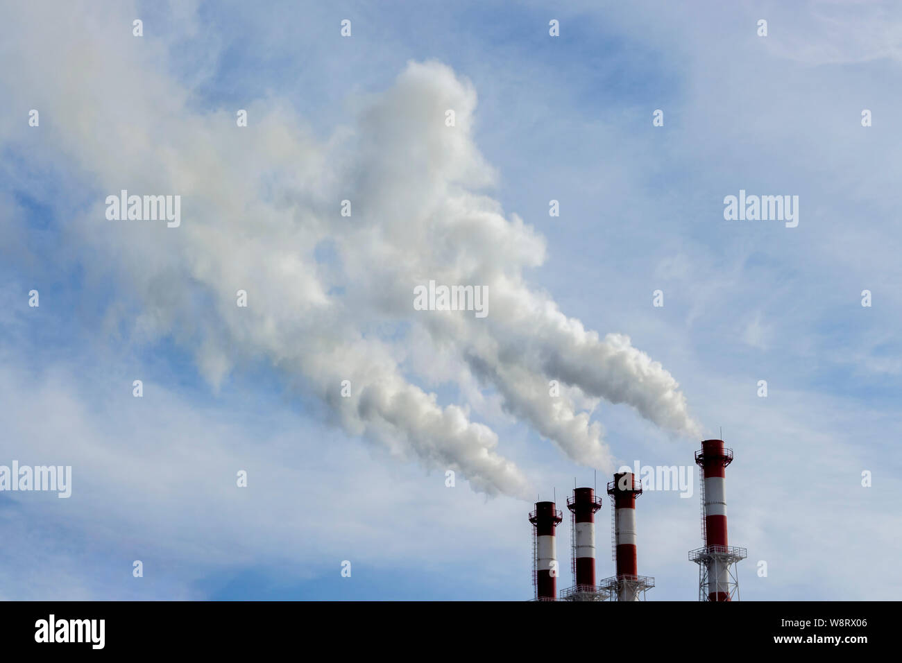 The red-white pipes of the boiler room release white steam into the ...