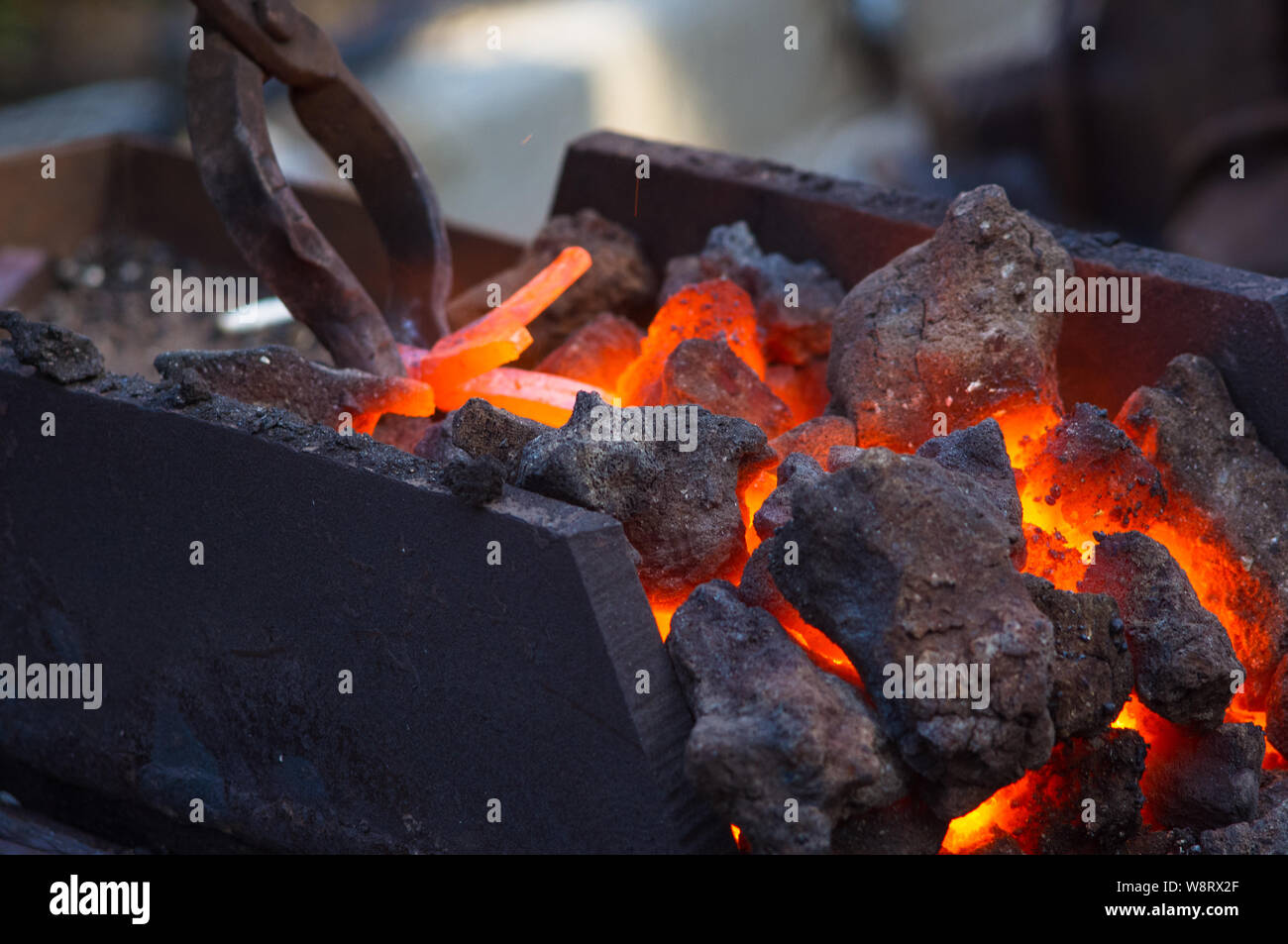 blacksmith furnace with burning coals, tools, and glowing hot metal ...
