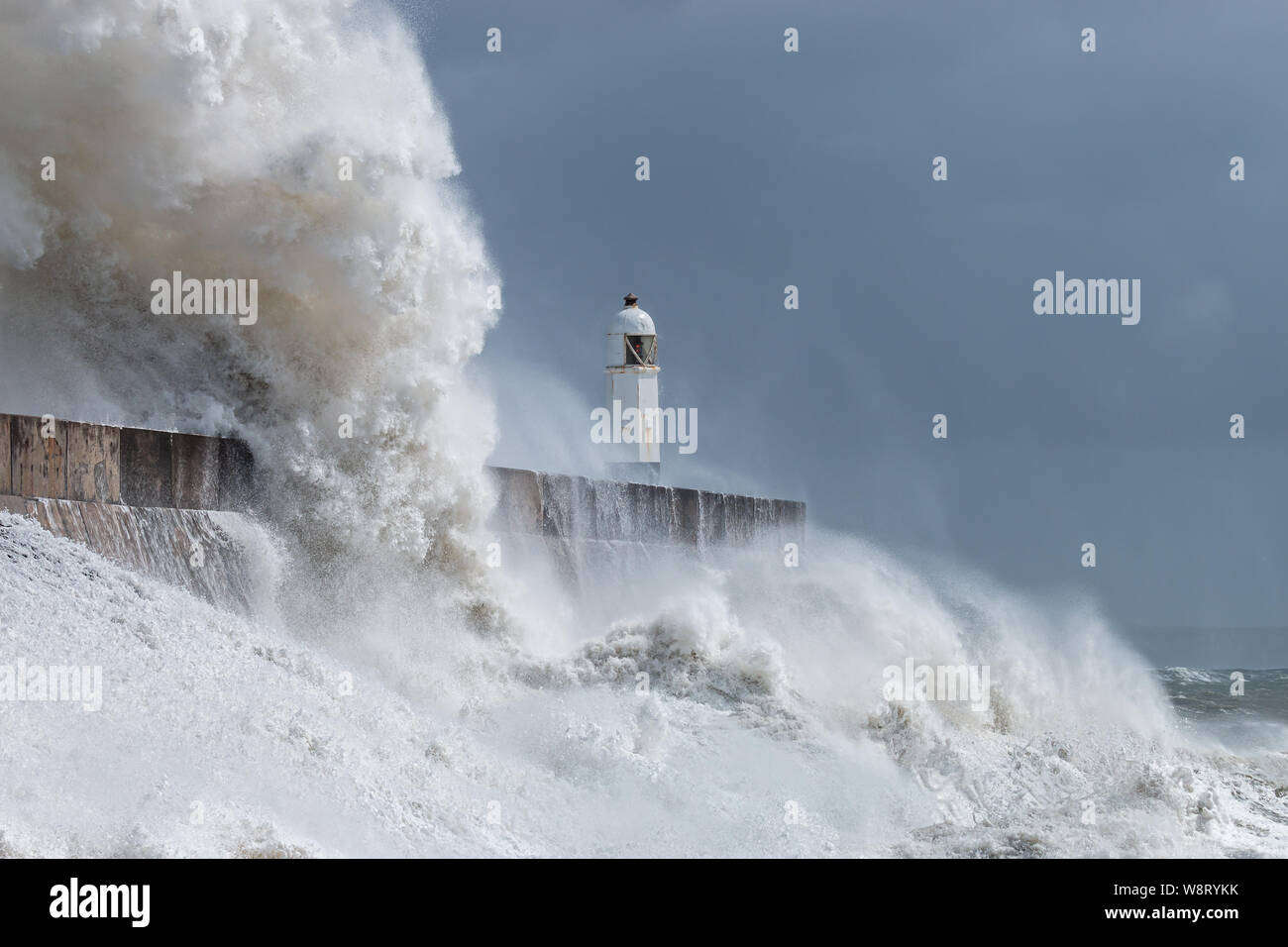 Huge ocean waves crashing into a sea wall and lighthouse (Porthcawl ...