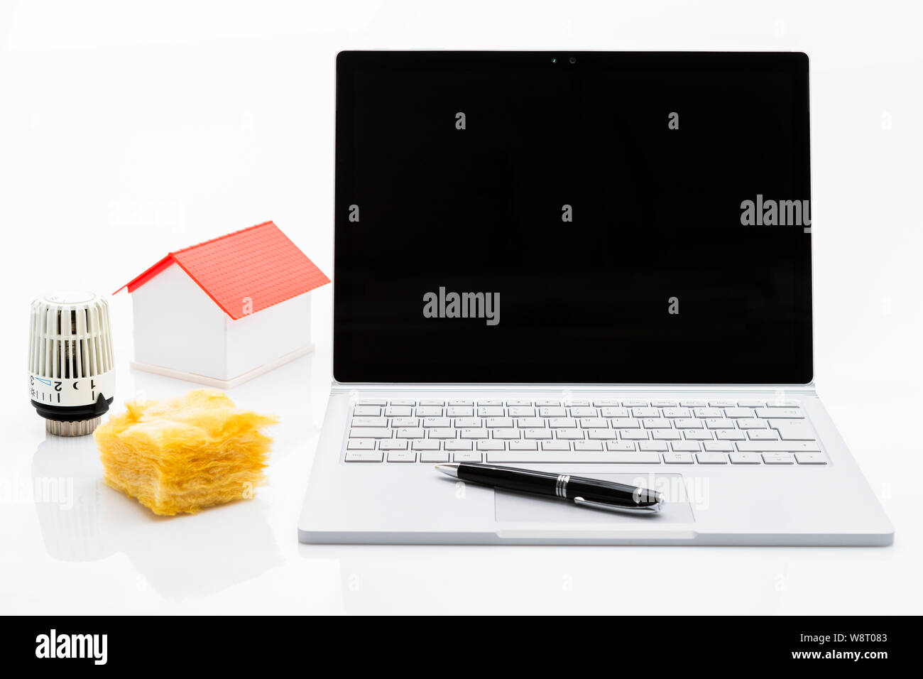 The photo shows a laptop with house, insulation wool and heating ...