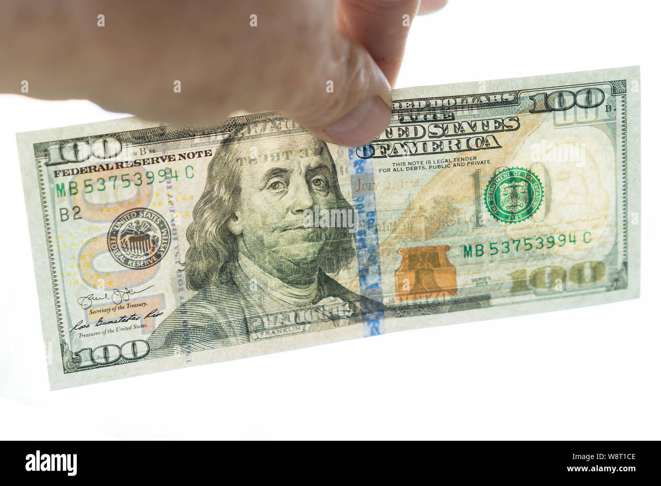 100 dollar bill in the hand. The reverse side is visible on a gleam ...