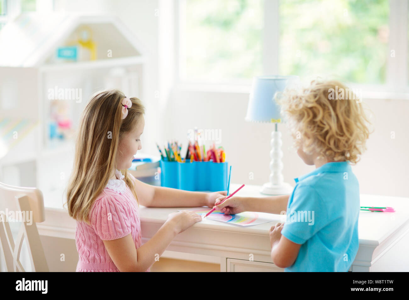 Child drawing rainbow. Kid painting at home. Little girl and boy doing ...