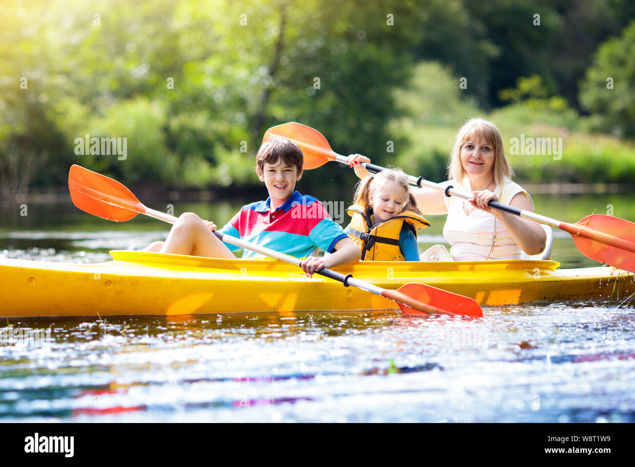 Child with paddle on kayak. Summer camp for kids. Kayaking and canoeing ...