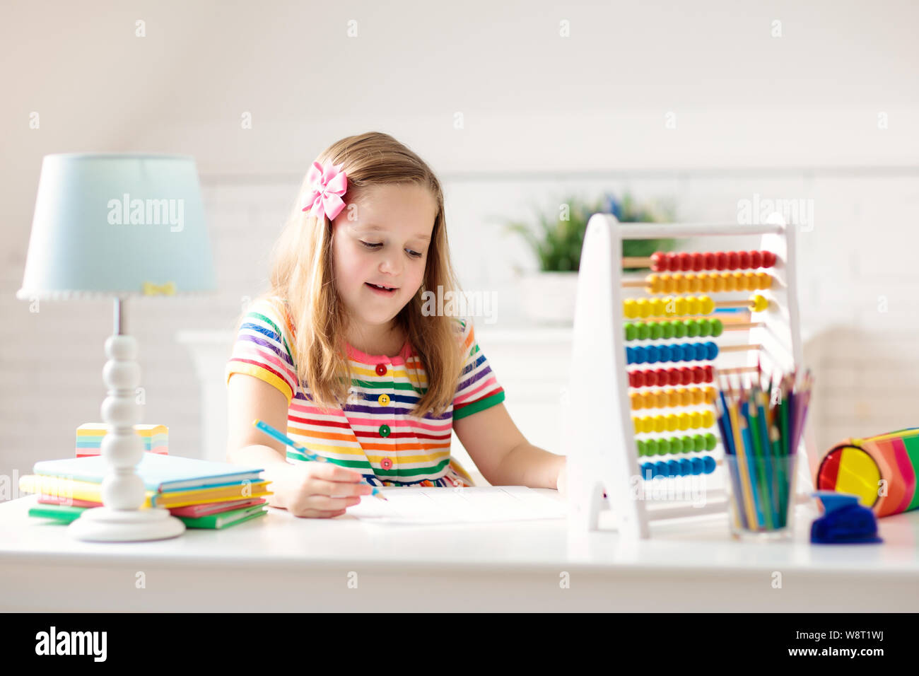 Child doing homework at home. Little girl with wooden colorful abacus ...