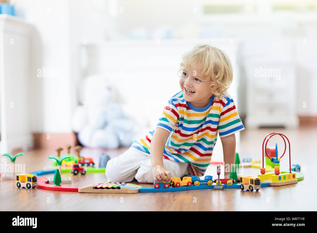 Kids play with wooden railway. Child with toy train. Educational toys ...