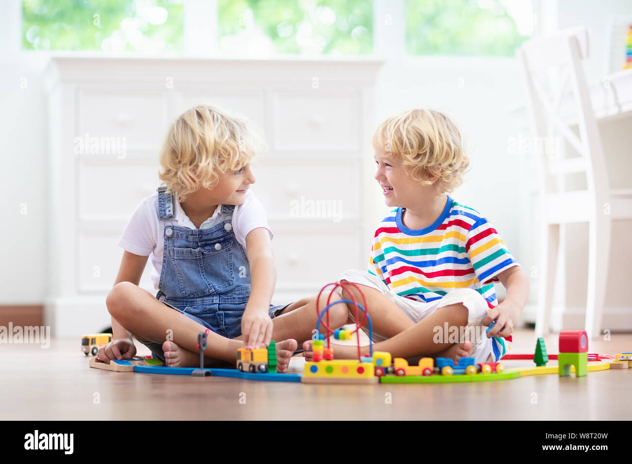 Kids play with wooden railway. Child with toy train. Educational toys ...