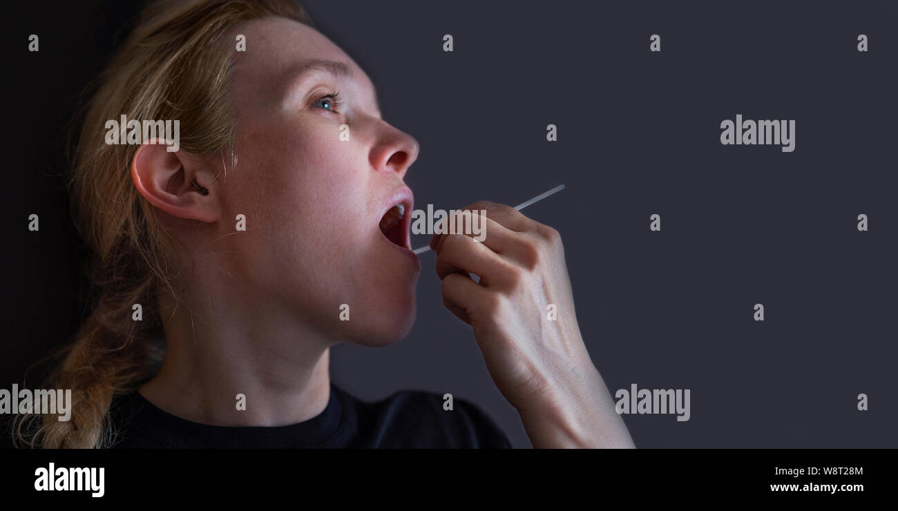 Woman doing DNA test with cotton swab at home. Test for home use ...