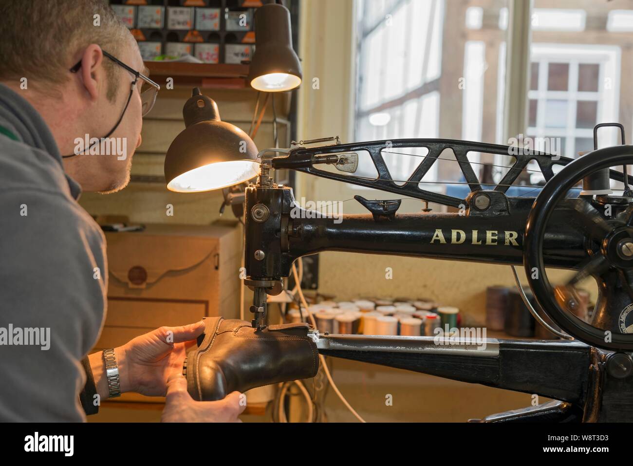 Shoemaker sews shoe to machine hi-res stock photography and images - Alamy