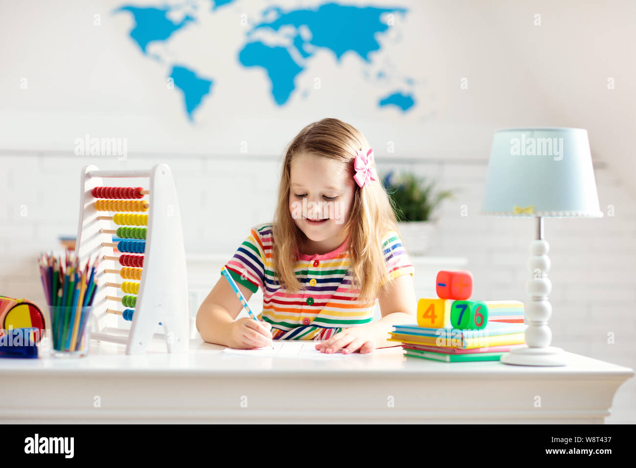 Child doing homework at home. Little girl with wooden colorful abacus ...