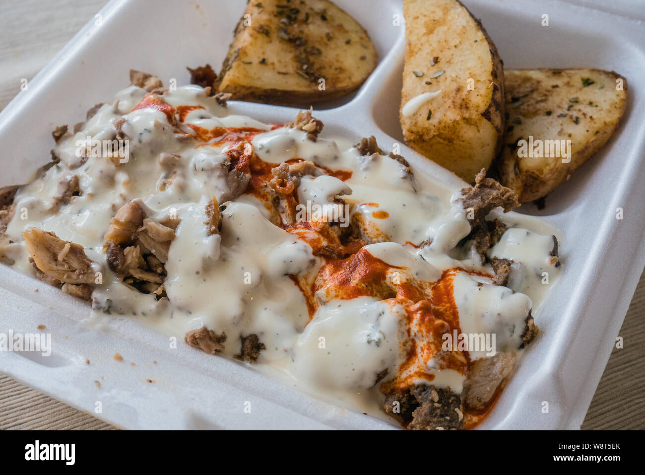 chicken and beef Shawarma with garlic sauce and potatos in a take out ...