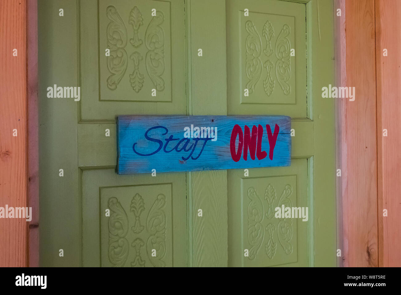 a blue staff only sign on a green door Stock Photo - Alamy