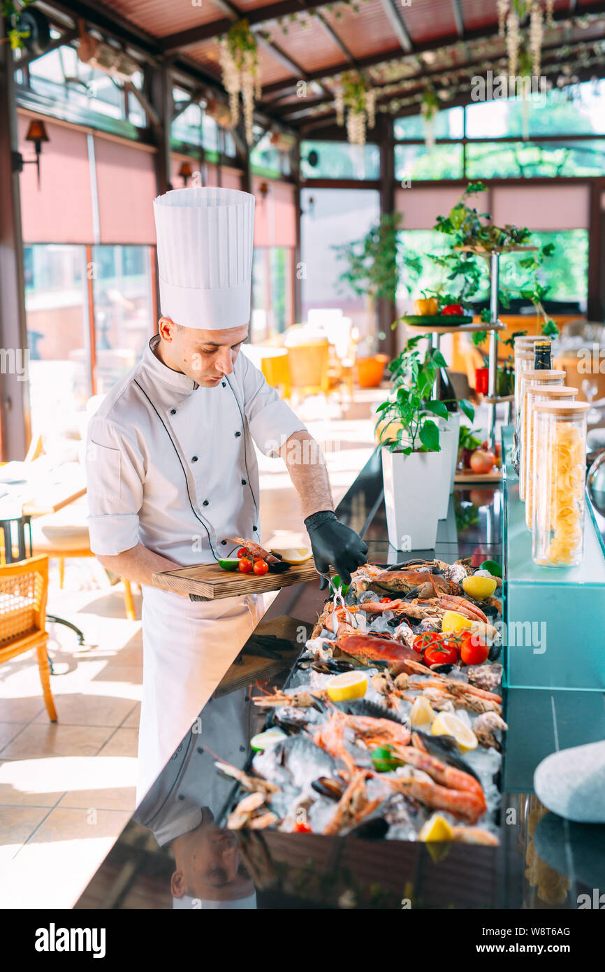 The Chef puts the seafood on a tray in the restaurant Stock Photo - Alamy
