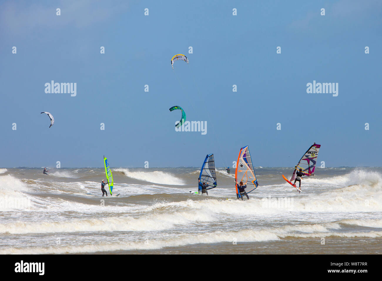 wind and kite surfing on high waves during summer storm on north sea ...