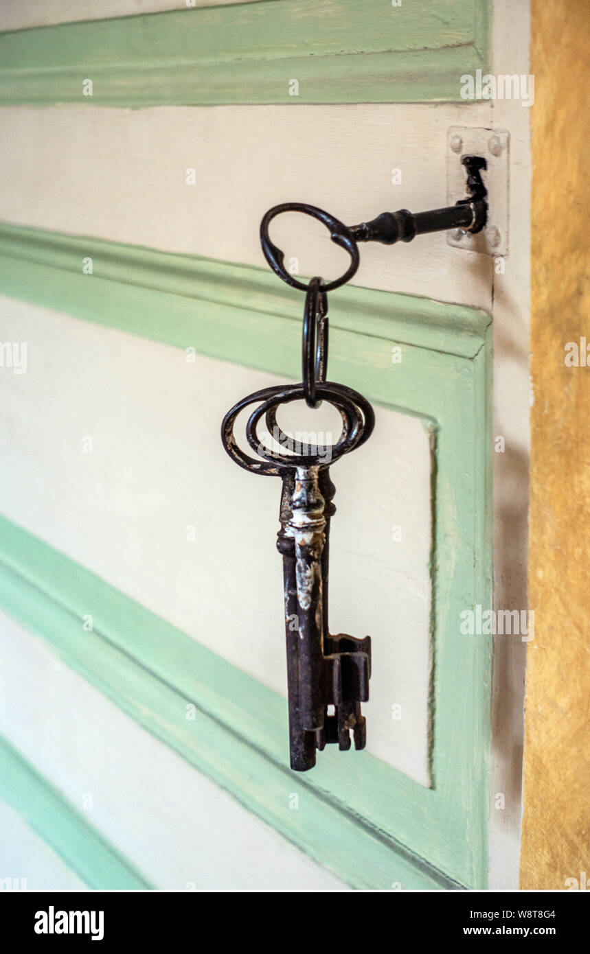 Old keys hanging out of keyhole in old french door hi-res stock ...