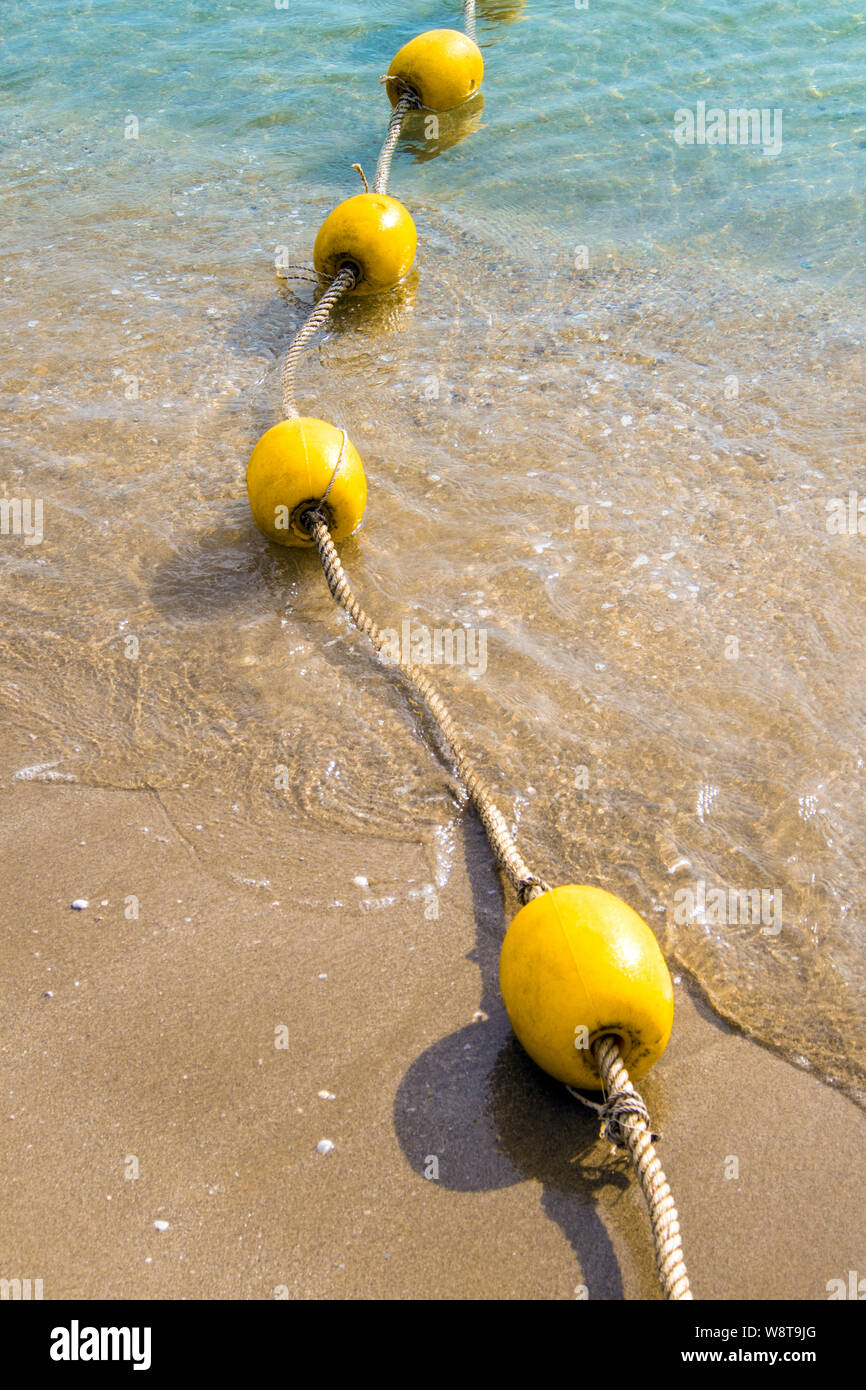 Floating buoy and rope dividing the area on the beach Stock Photo - Alamy