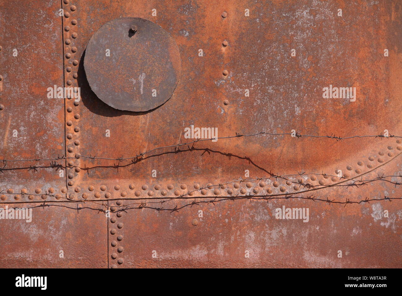 rusty steel with rivets, loophole and barbed wire Stock Photo - Alamy