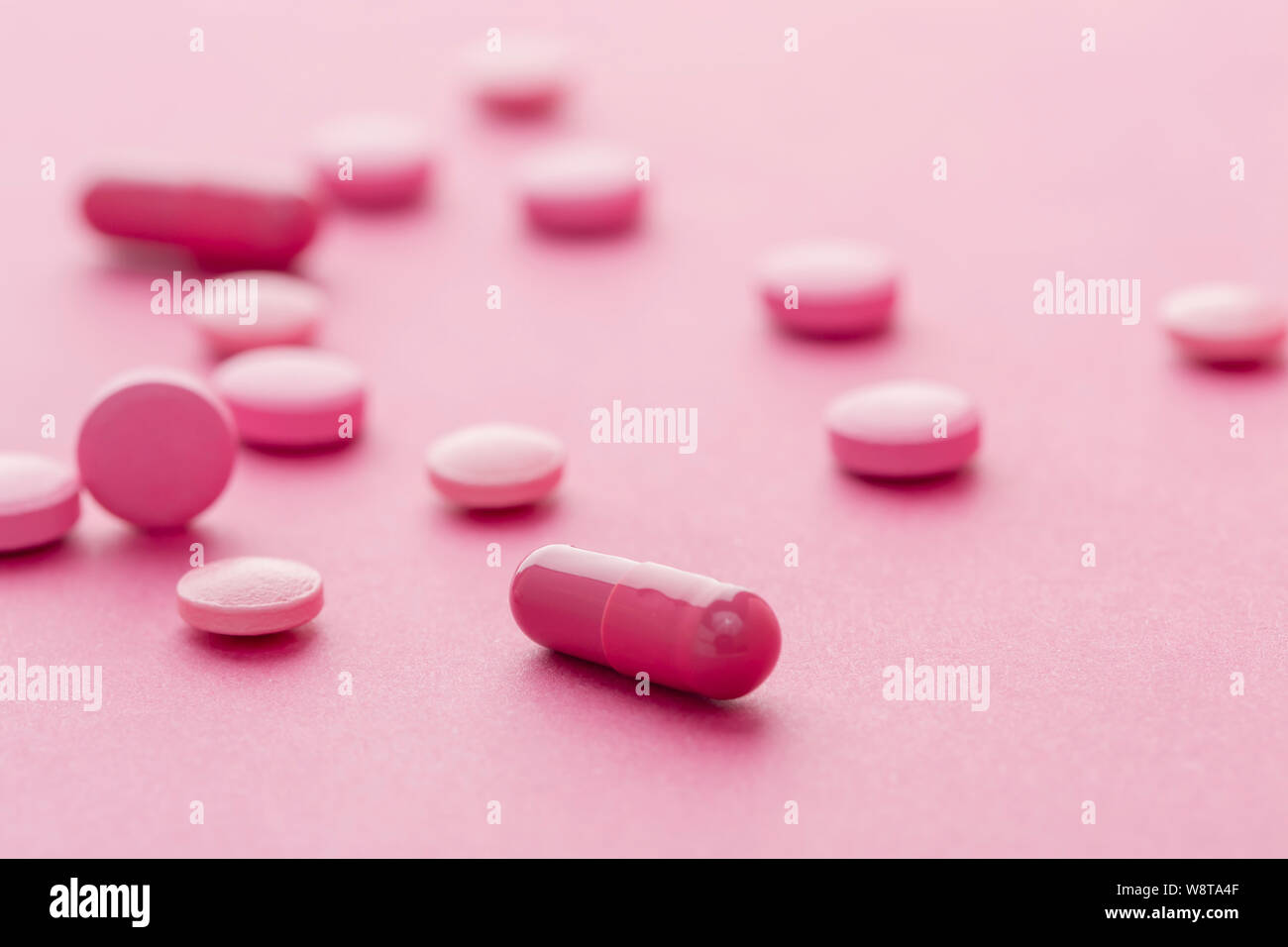Various red colour medication capsules. Red background Stock Photo - Alamy