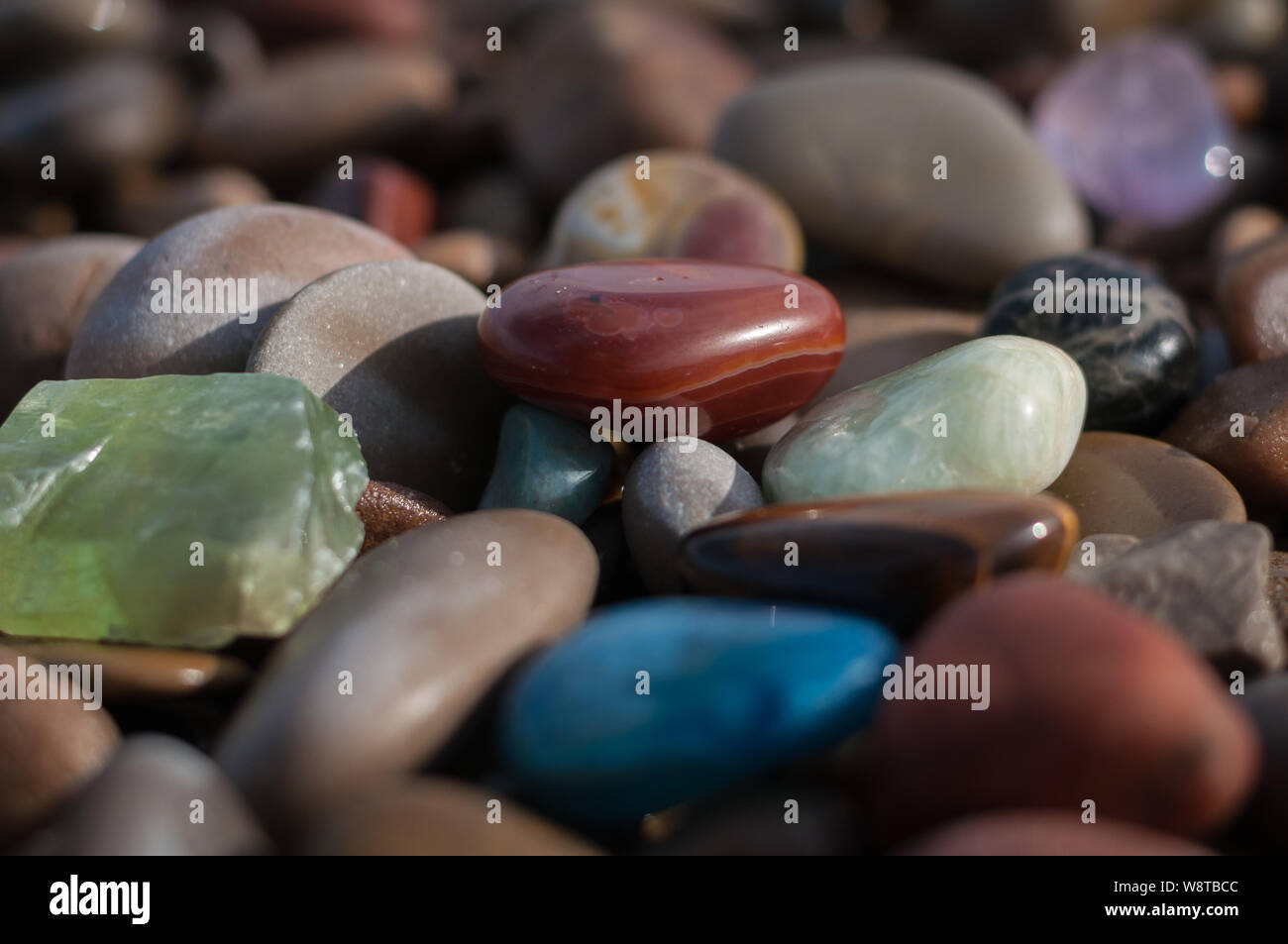 colored minerals on the stone beach in bulk Stock Photo - Alamy