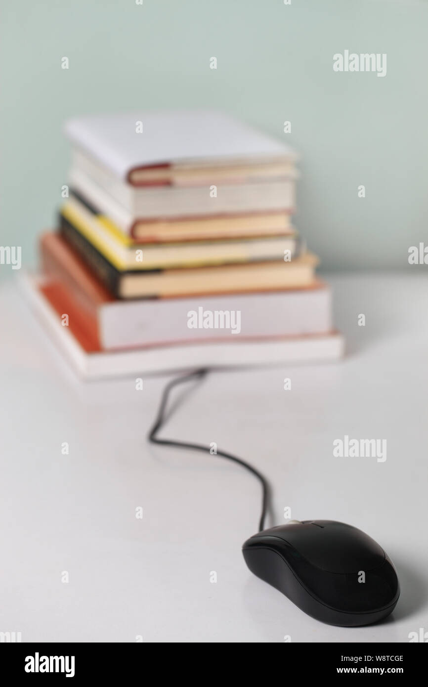 Stack of books connected with a computer mouse Stock Photo - Alamy