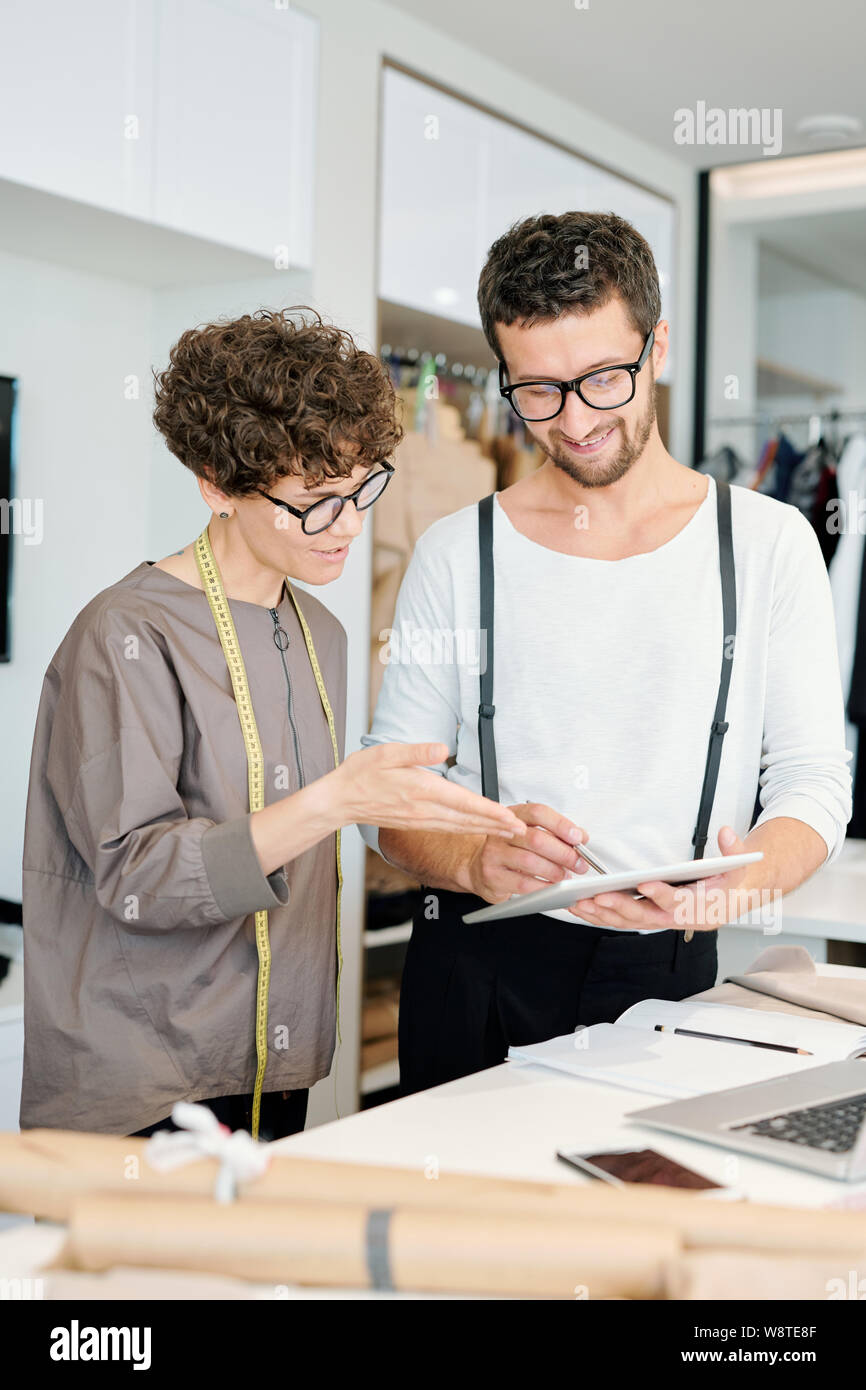 Two young creative designers pointing at touchpad display Stock Photo ...