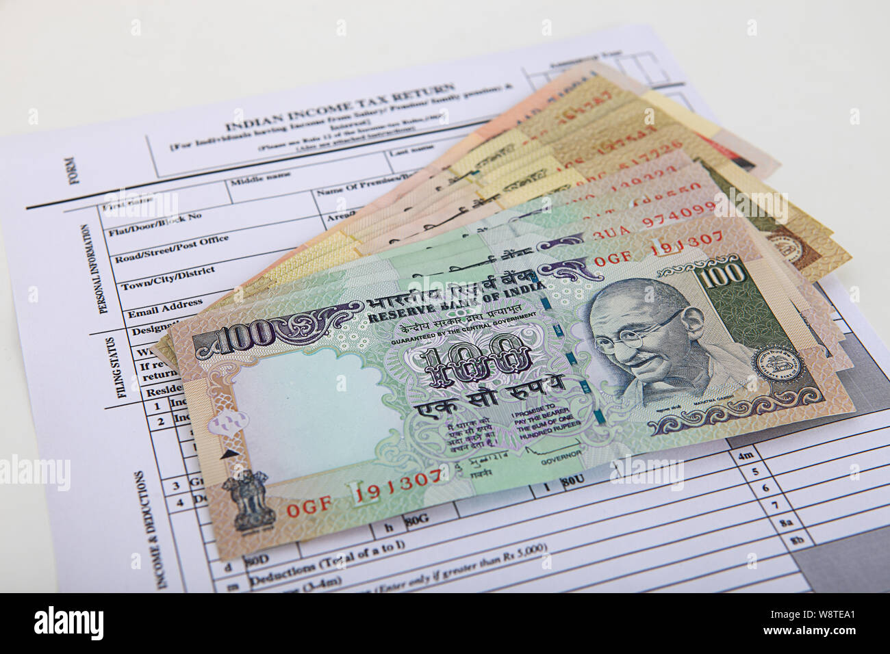 Indian currency on an income tax return form Stock Photo - Alamy