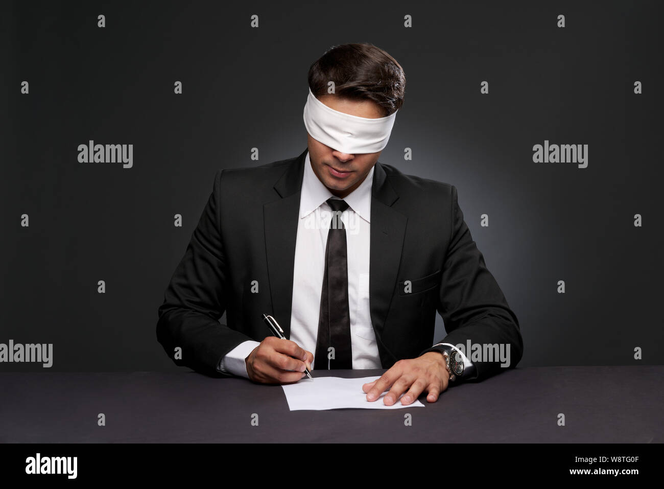 Blindfolded businessman carelessly signing a contract Stock Photo - Alamy