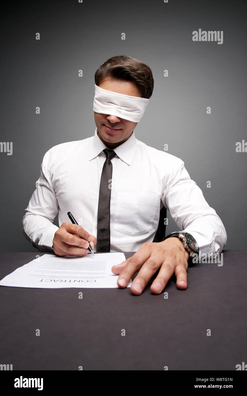 Blindfolded businessman carelessly signing a contract Stock Photo - Alamy