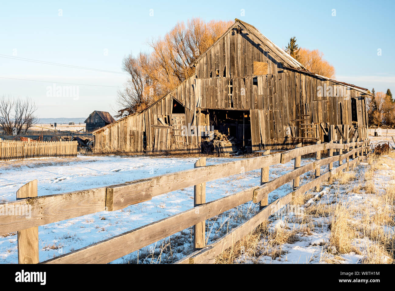 Winter on a farm with a fence and wooden barn Stock Photo - Alamy
