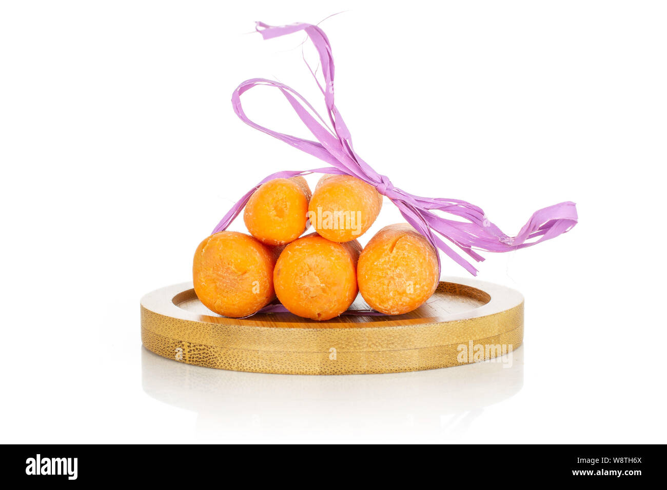 Group of five whole stale orange stale baby carrot baby on bamboo plate ...