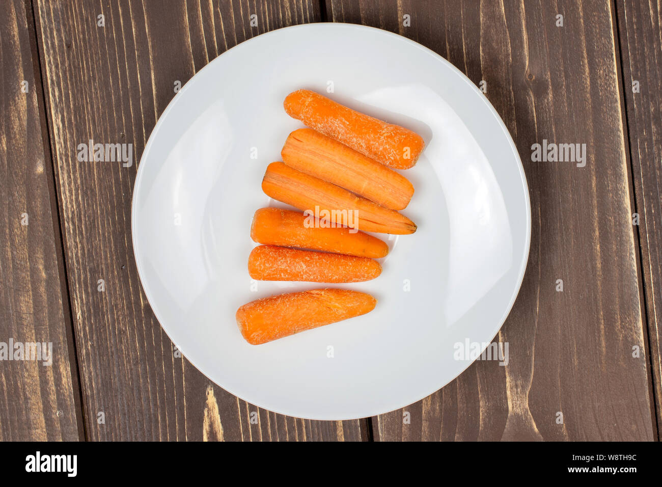 Lot of whole stale orange stale baby carrot baby on white porcelain ...