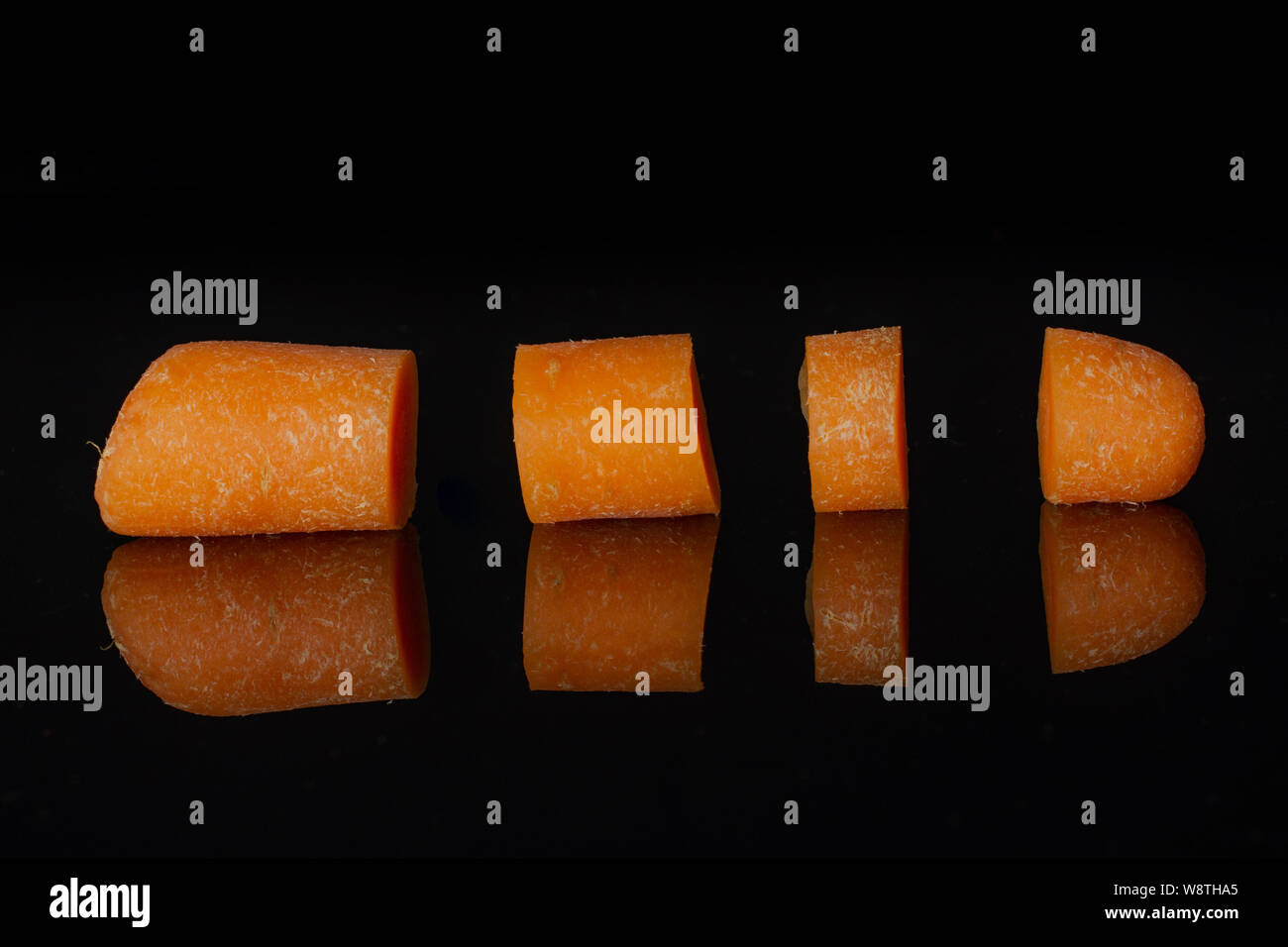 Group of four quarters of stale orange stale baby carrot baby isolated ...
