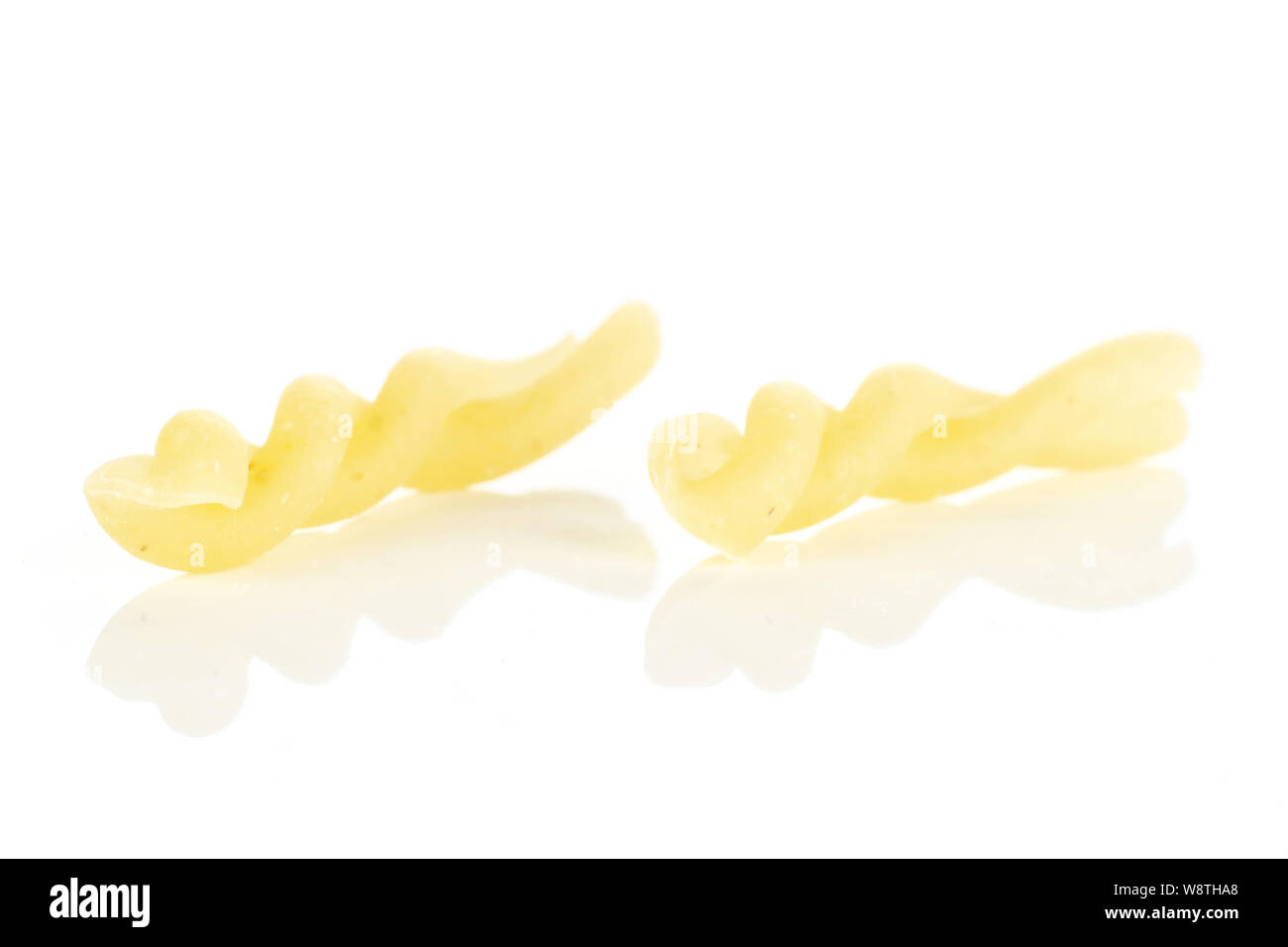 Group of two whole twisted raw pasta gemelli isolated on white ...
