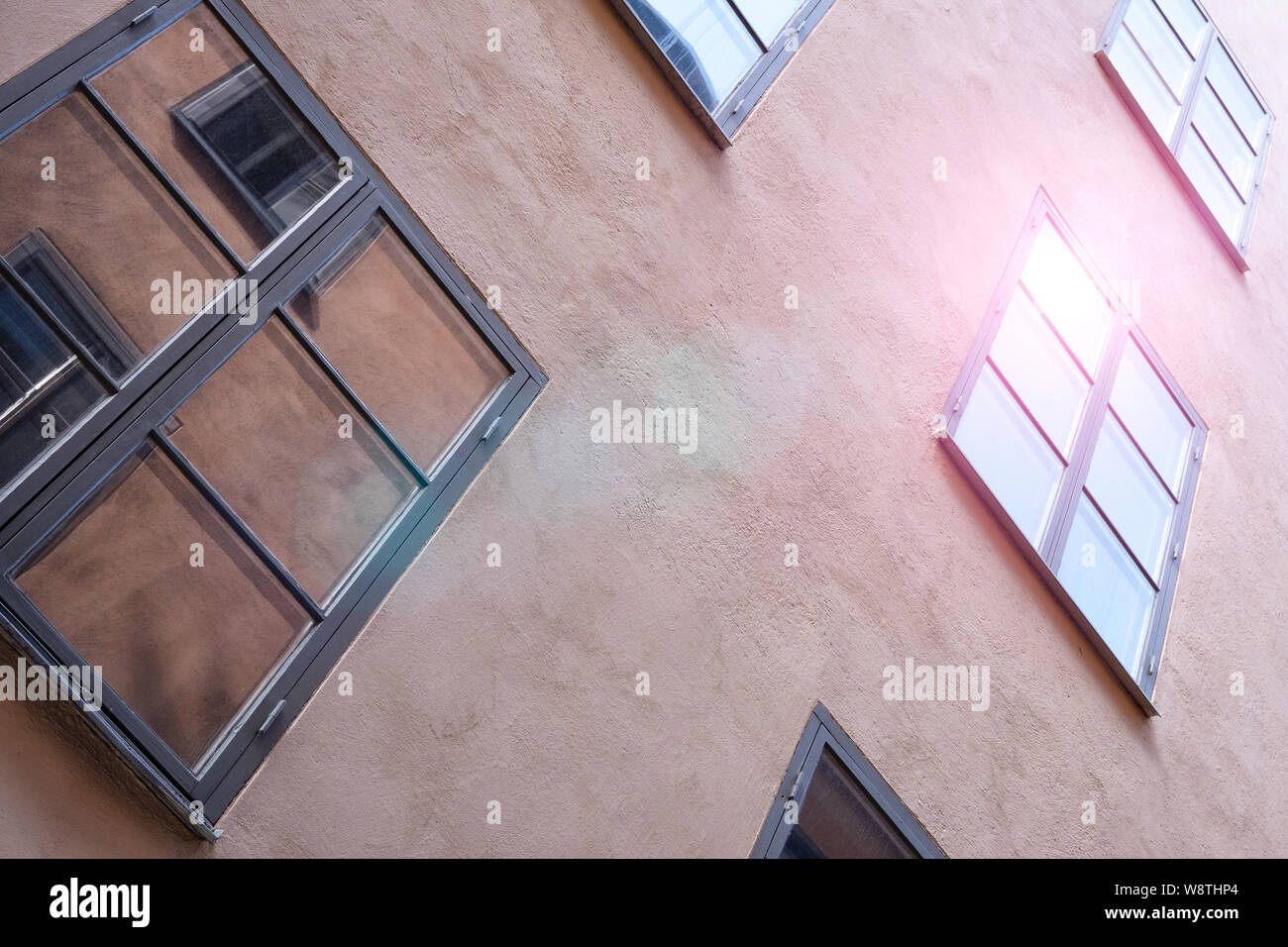 Part of the facade of a brown historic building illuminated, reflecting ...