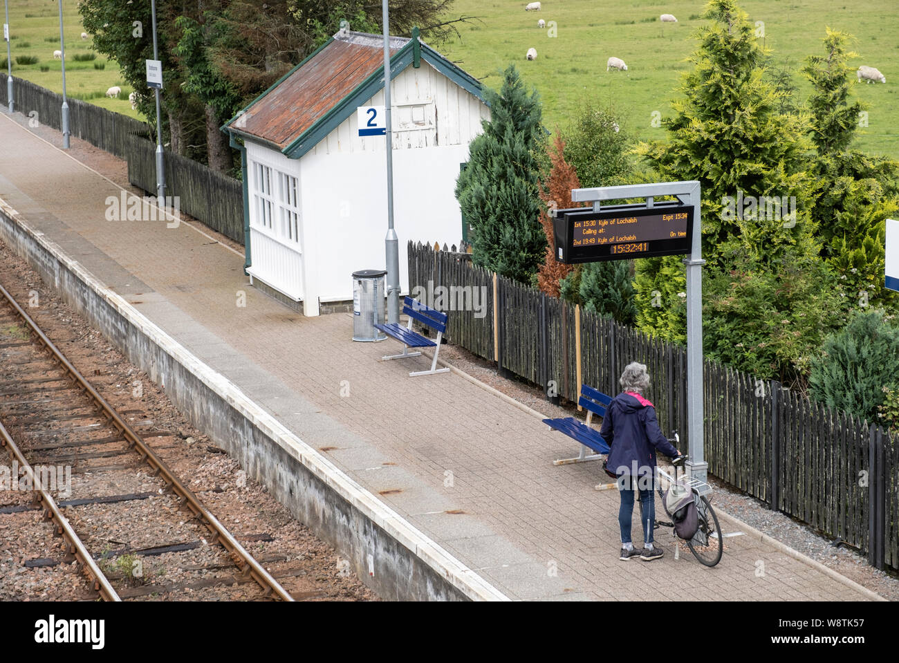 Passenger with bicycle under destination sign awaiting ScotRail train ...