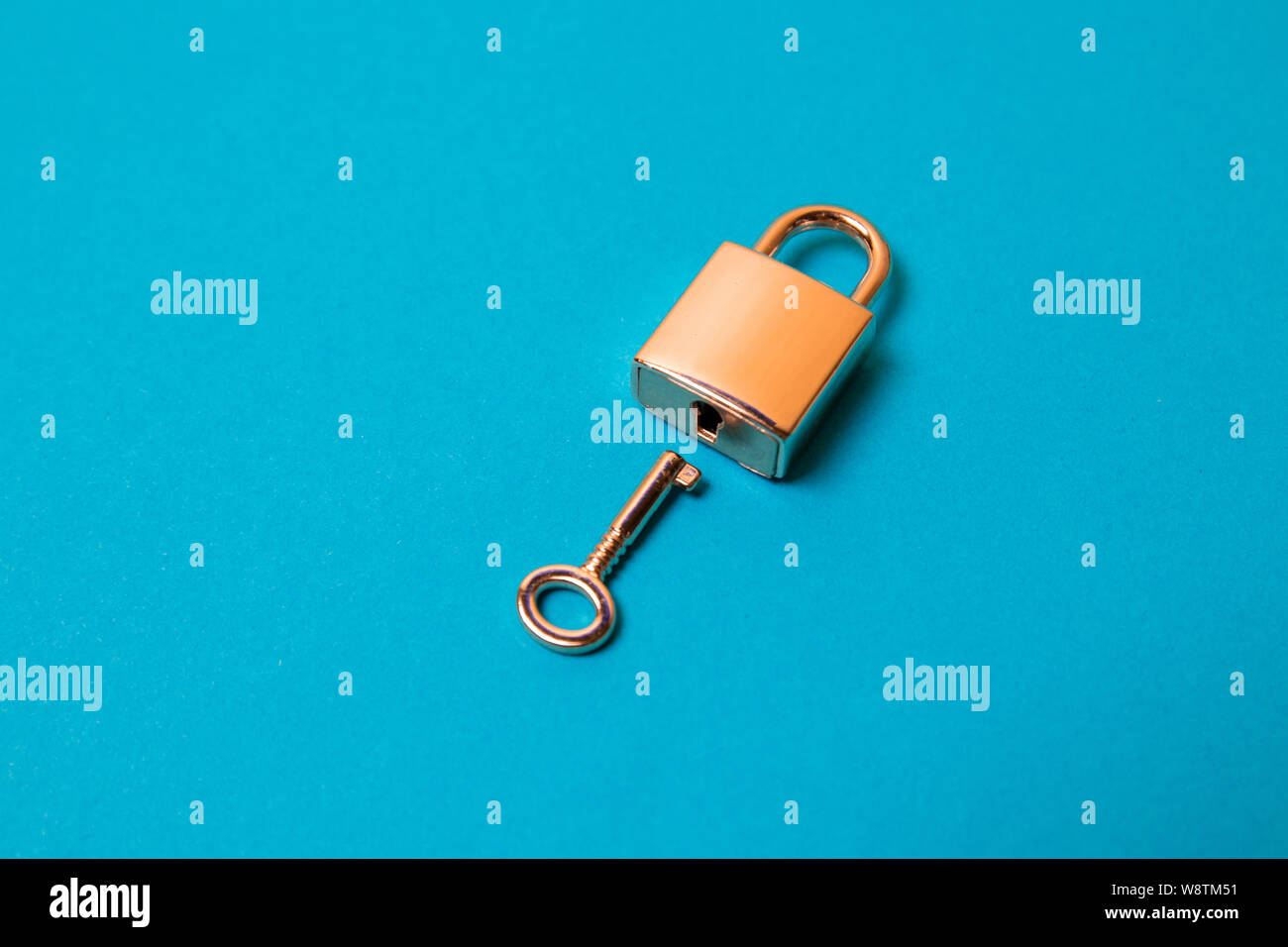 Flat lay protection concept. Locked padlock and key on the blue ...