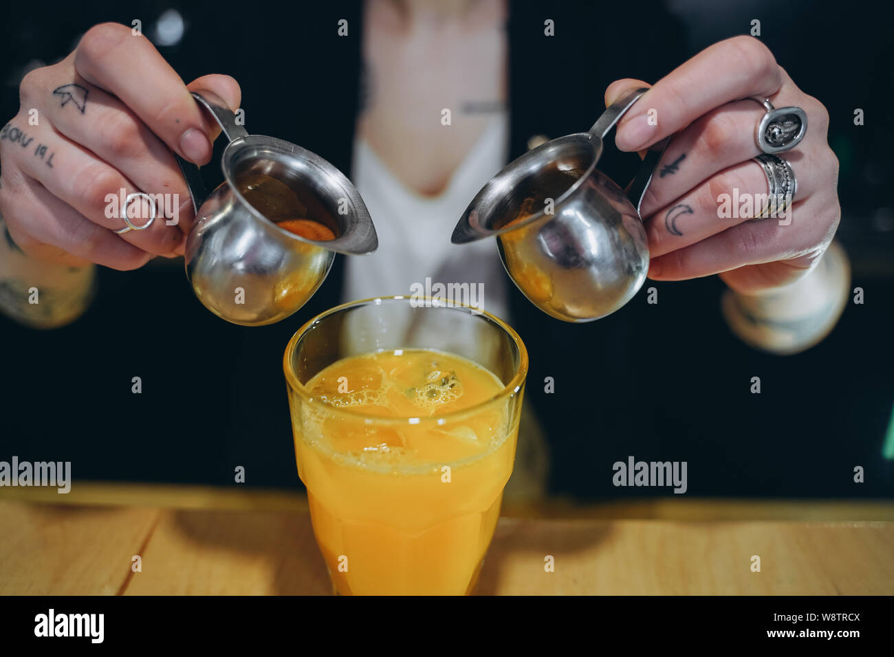 KIEV, UKRAINE - APRIL 14, 2019 A girl makes a orange coffee cocktail ...