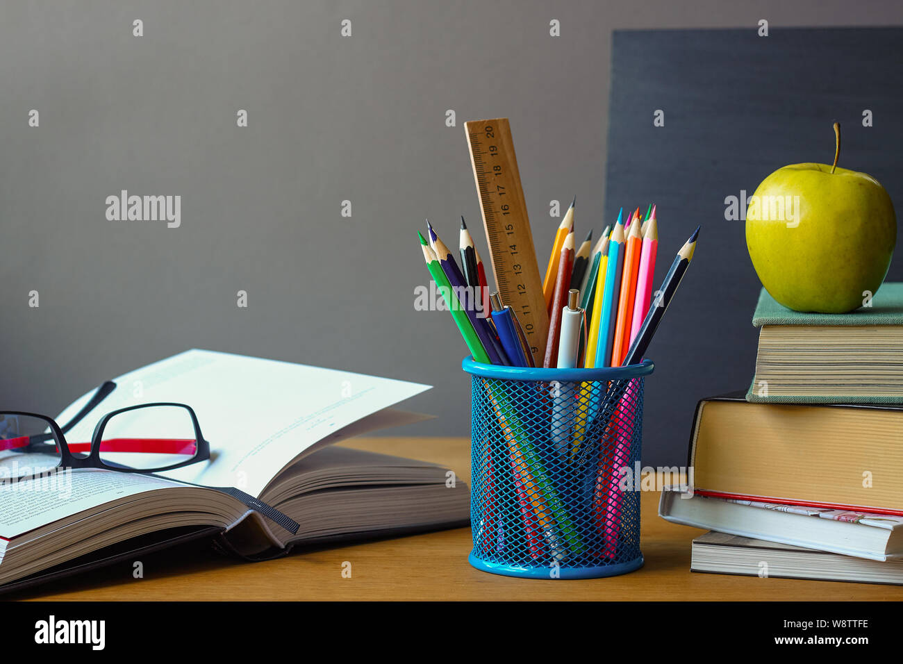Back to school concept, school supplies, stack of books, chalk board ...