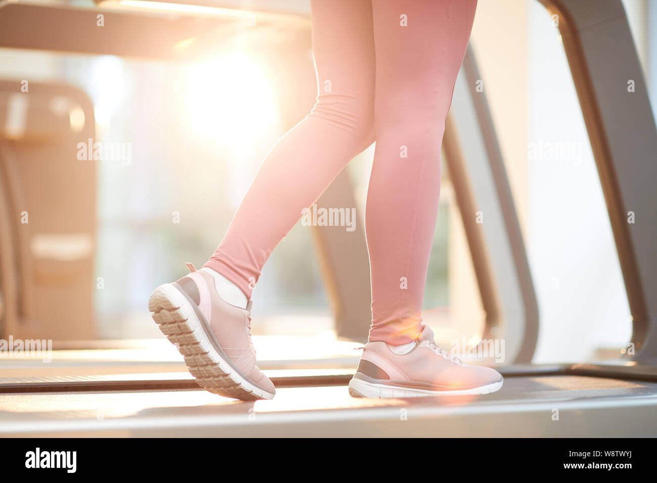Sports background of slender female legs running on treadmill in gym ...